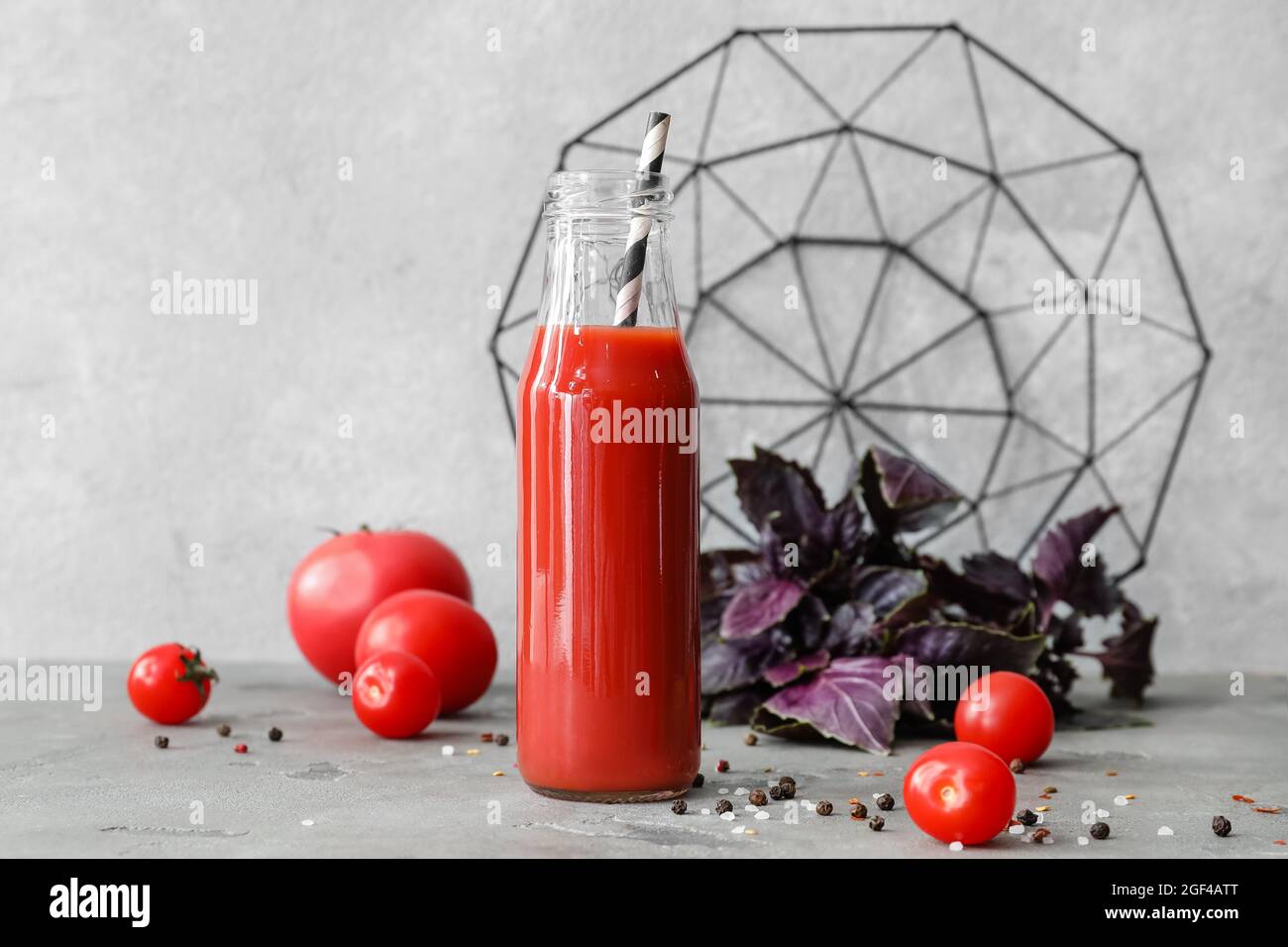 Bottle of tasty tomato juice on grey background Stock Photo - Alamy