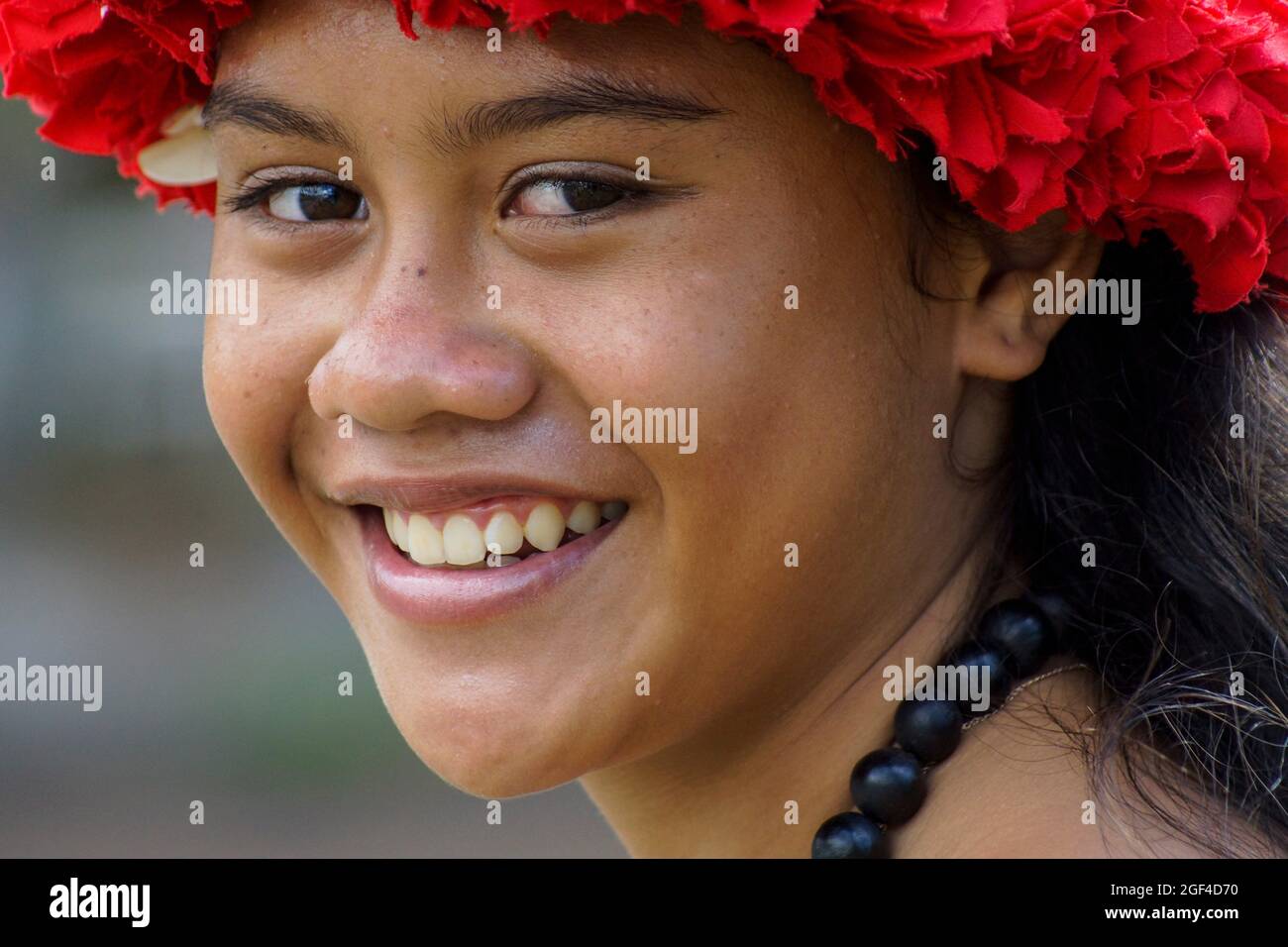 A young Marquesan woman greets arriving cruise passengers with a warm ...