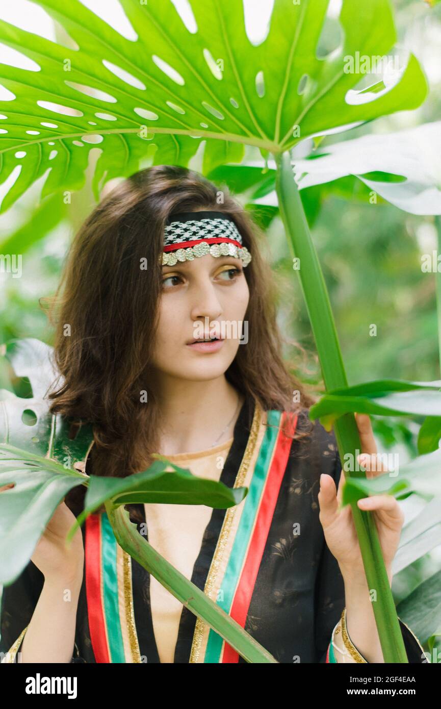 The girl from Jordan on the background of plants and palm leaves ...