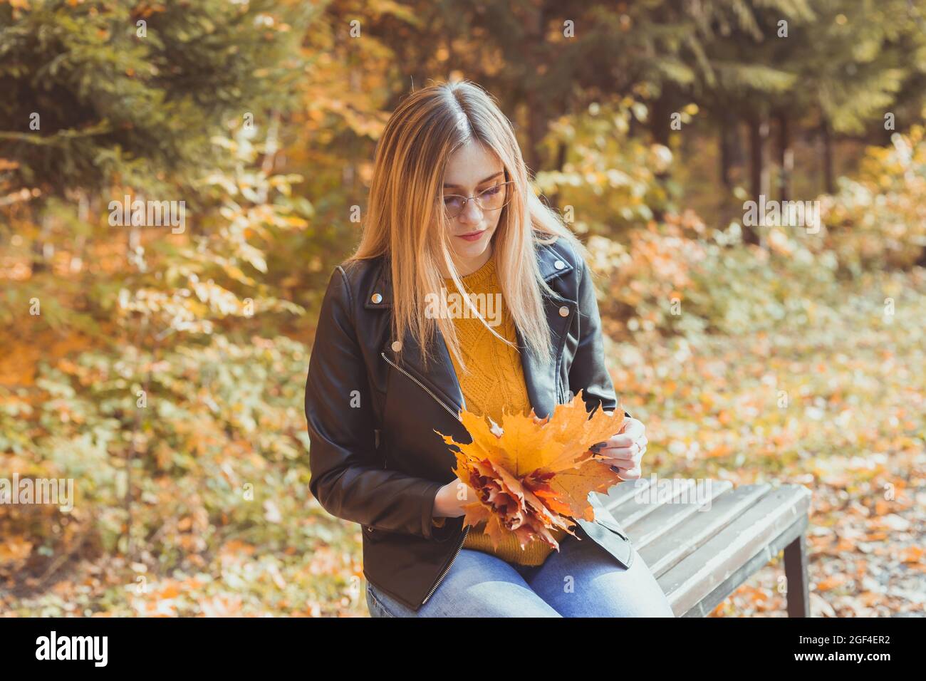 Cute smiley woman holding autumn leaves in fall park. Seasonal ...