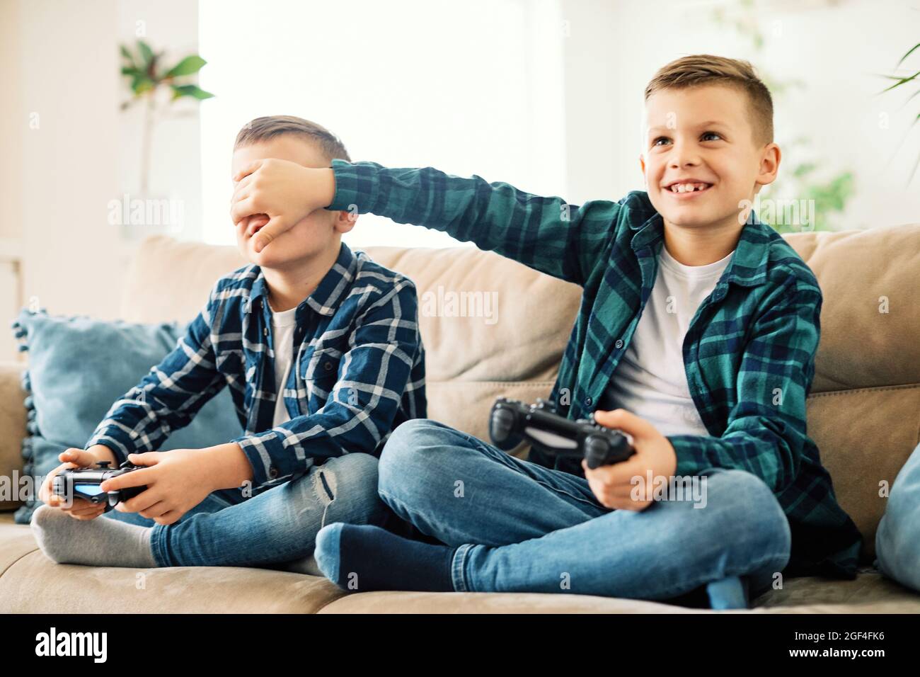 child brother friend having fun playing console laughing happy kid ...