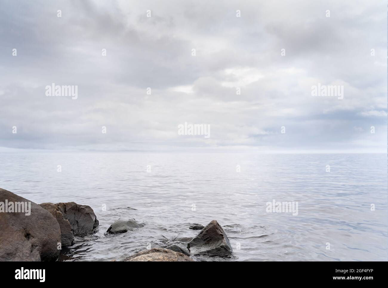 Beautiful autumn misty grey lake with rocky shore and cloudy sky at ...
