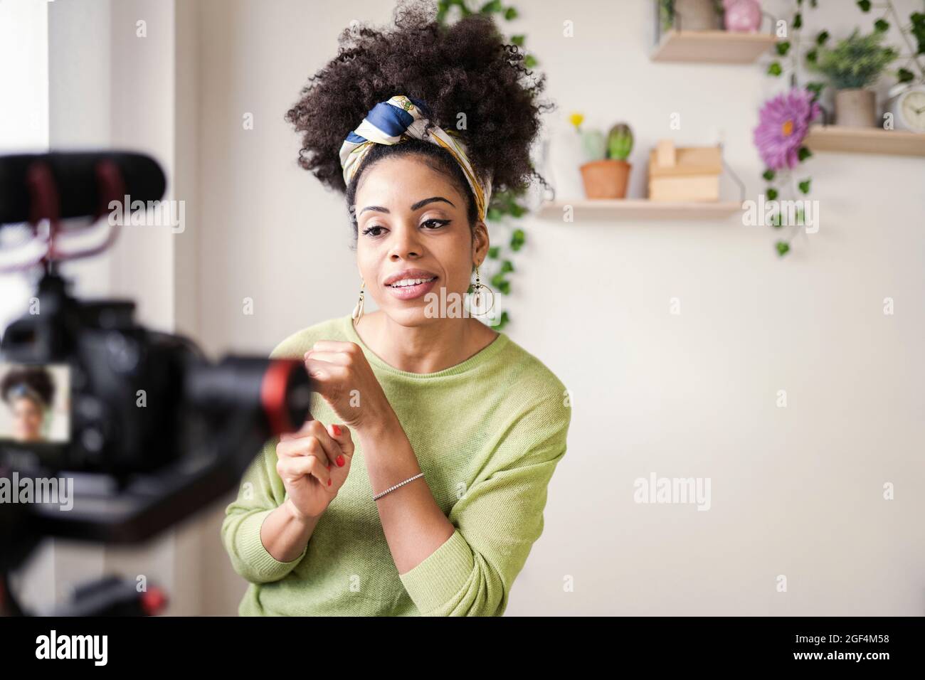 Young woman wearing headband filming through camera at home Stock Photo ...