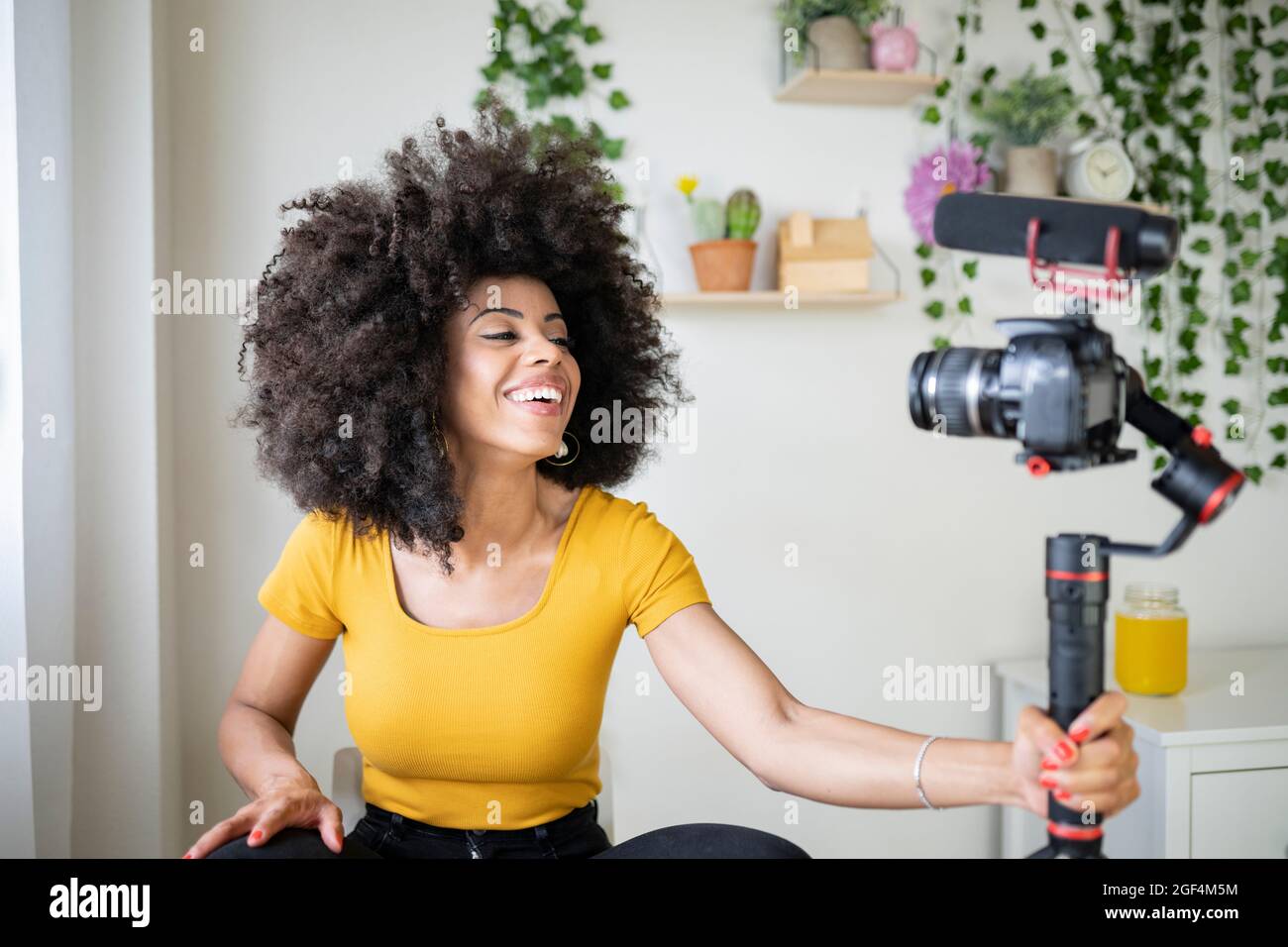 Happy female influencer vlogging through camera at greenhouse Stock ...