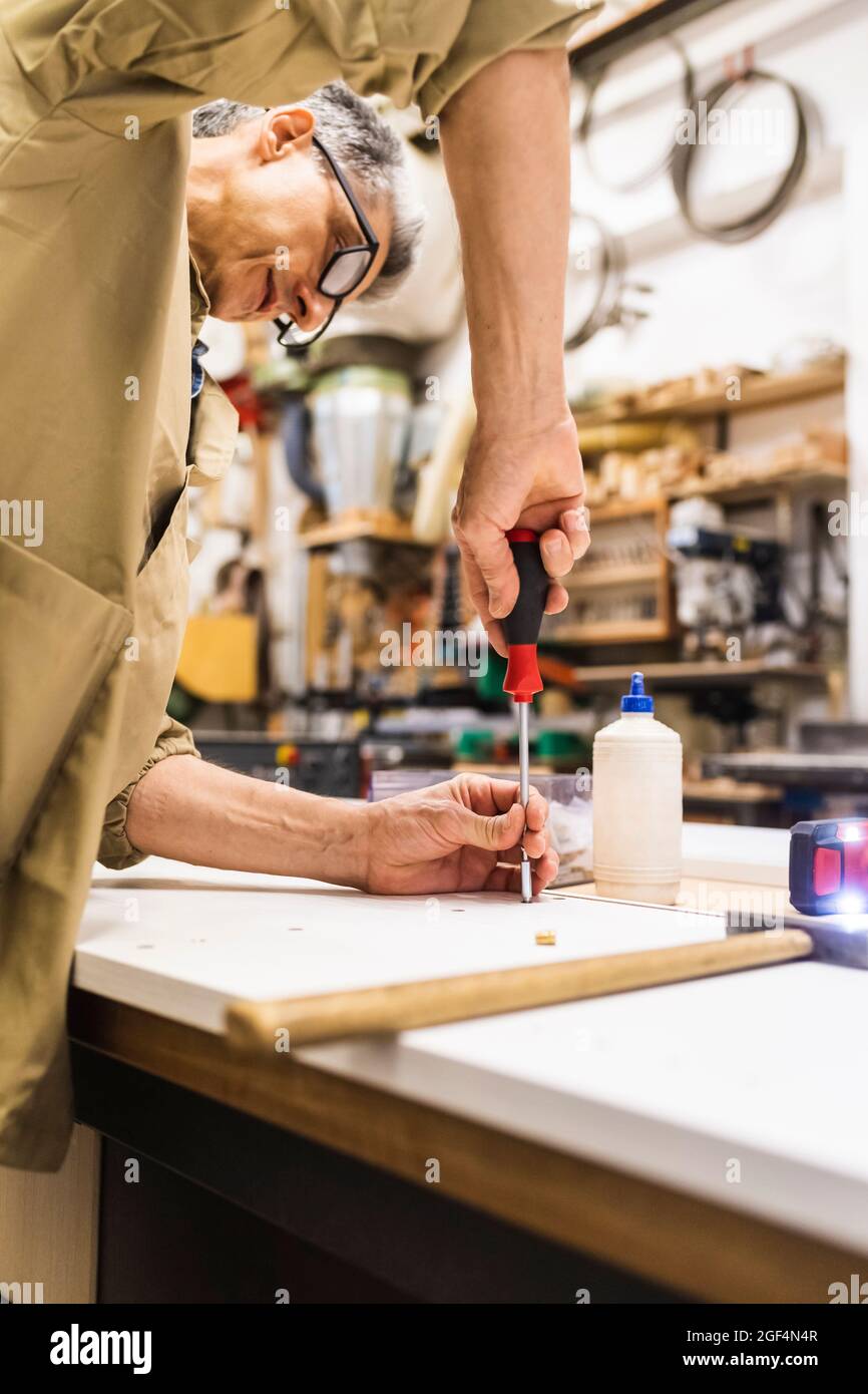 Mature man using screwdriver hi-res stock photography and images - Alamy