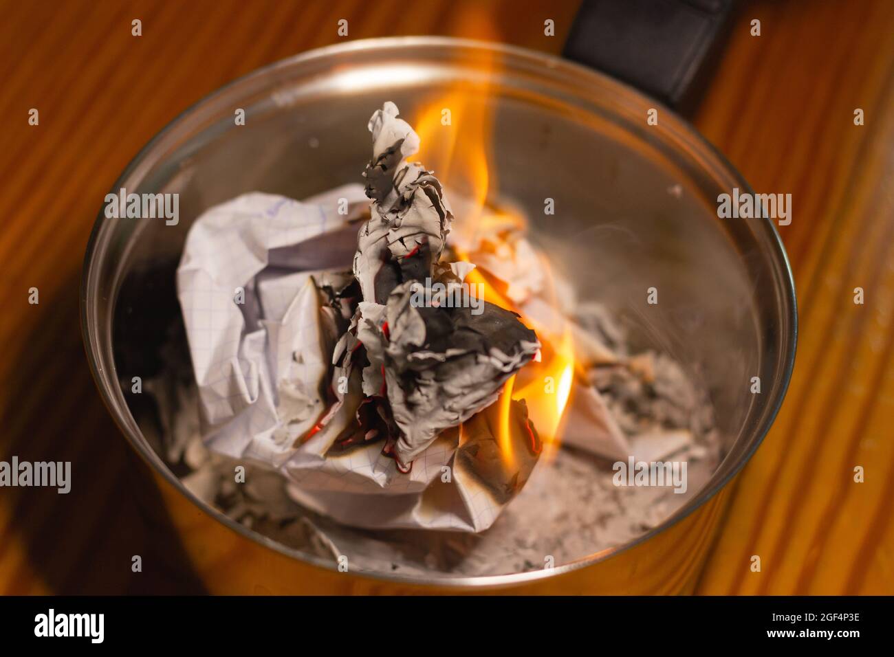 Documents in flames on small silver pot. Official documents destruction ...
