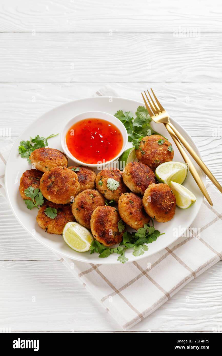 Tod man pla, thai fish cakes with sweet chili sauce on a white plate ...
