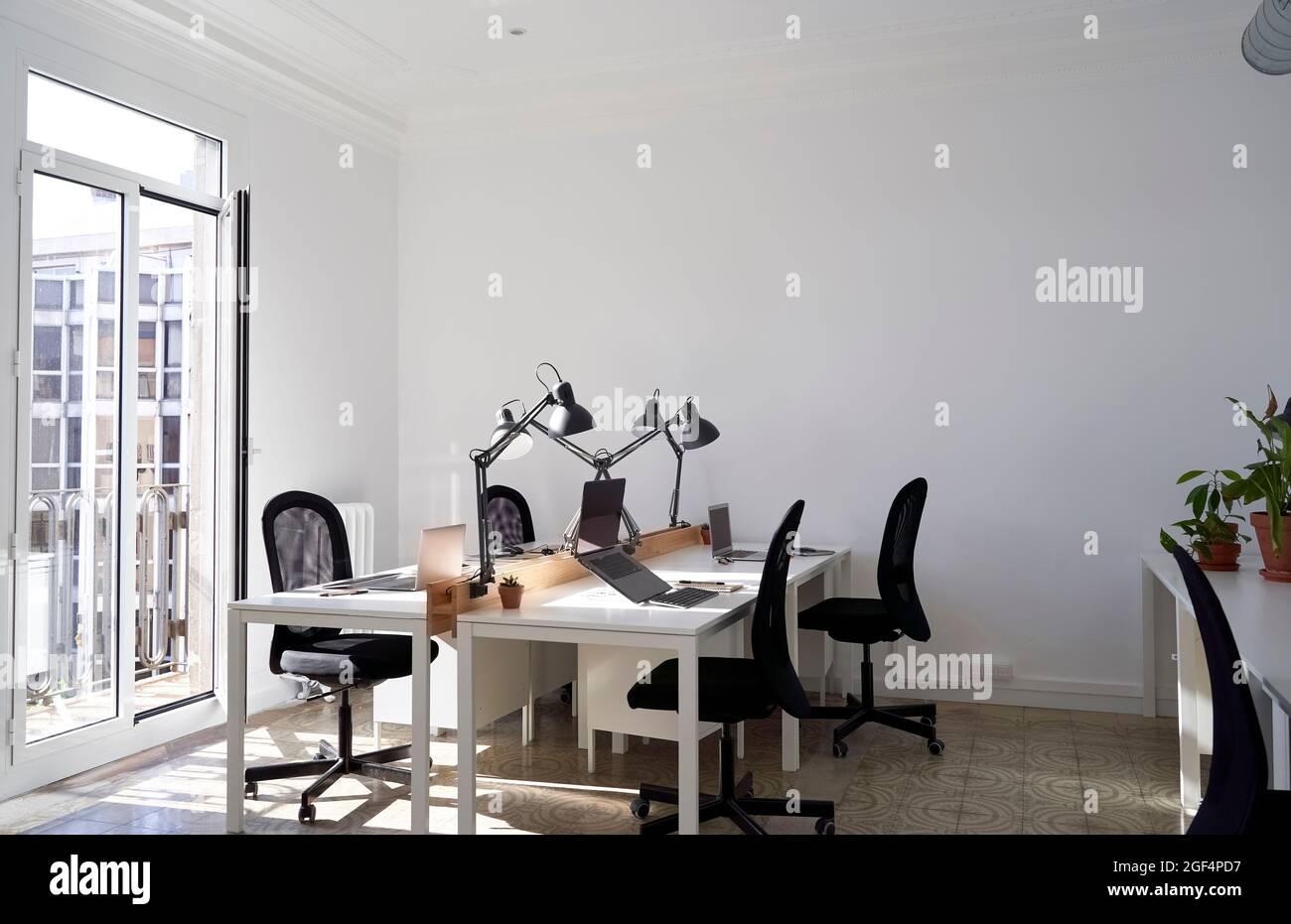 Chairs arranged at desks in coworking office Stock Photo - Alamy