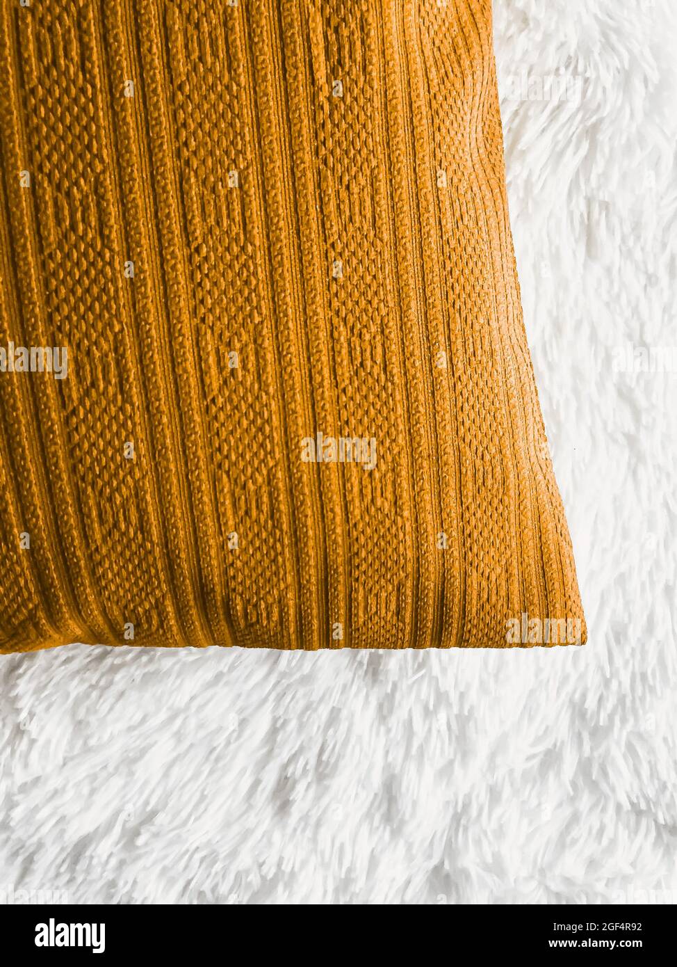 Golden cushion throw pillow on white fluffy plaid blanket as flat lay ...