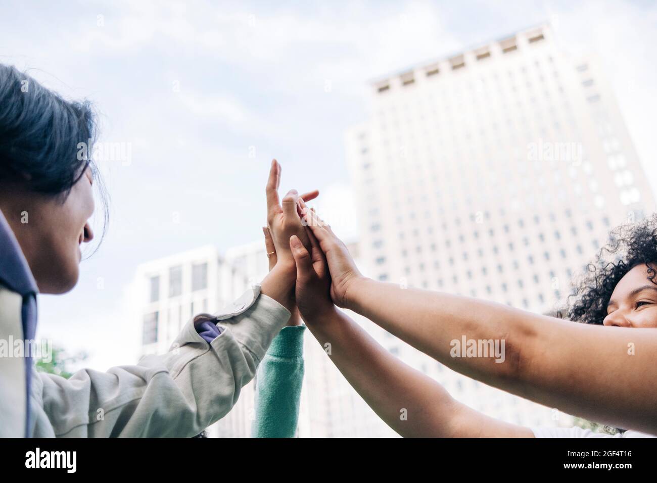 Male and female friends giving high five to each other Stock Photo - Alamy