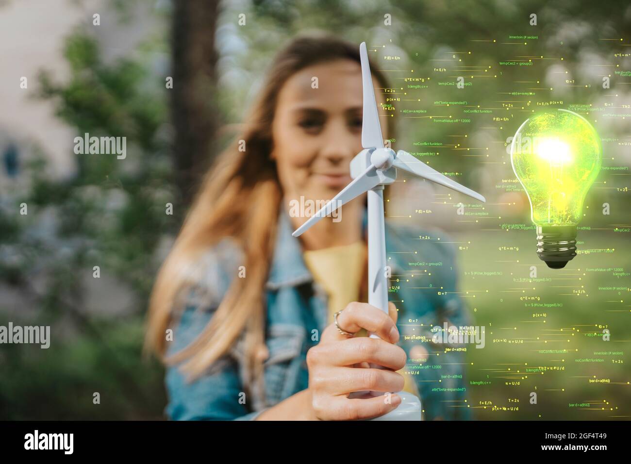 Woman holding windmill model near illuminated light bulb Stock Photo ...