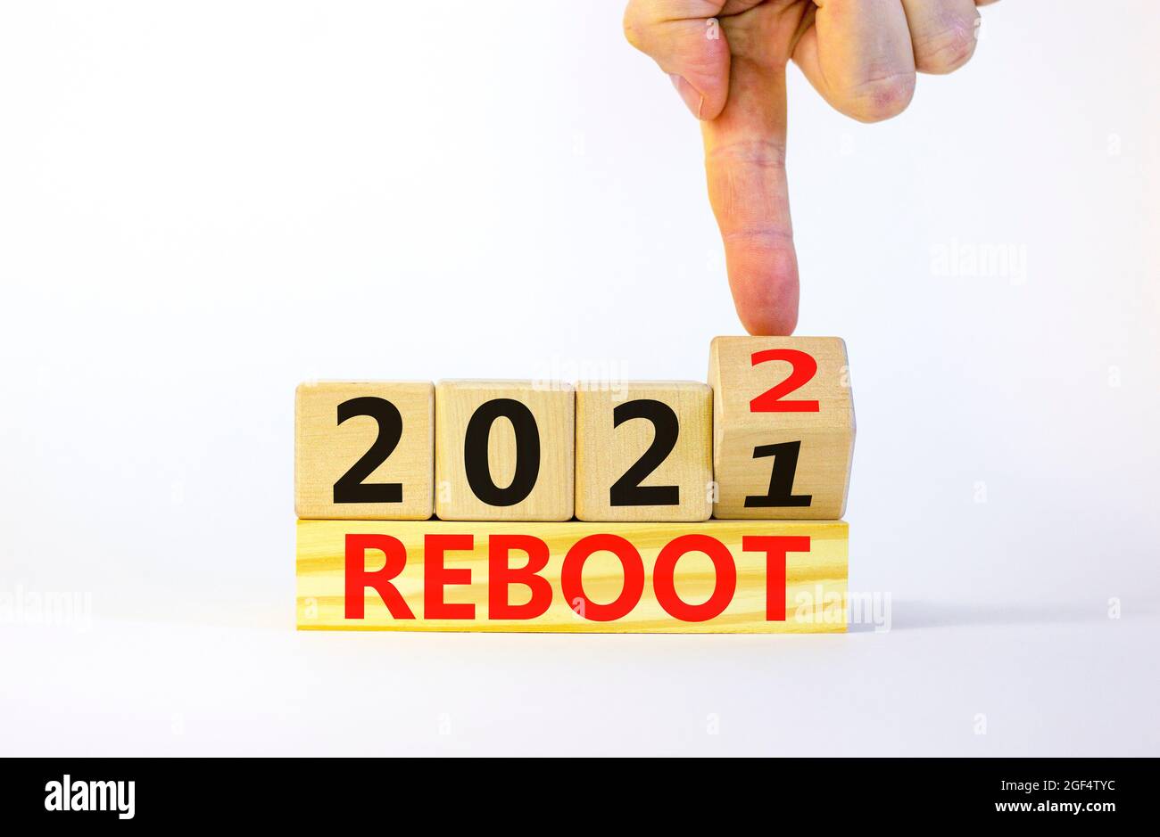 2022 reboot new year symbol. Businessman turns a wooden cube and ...