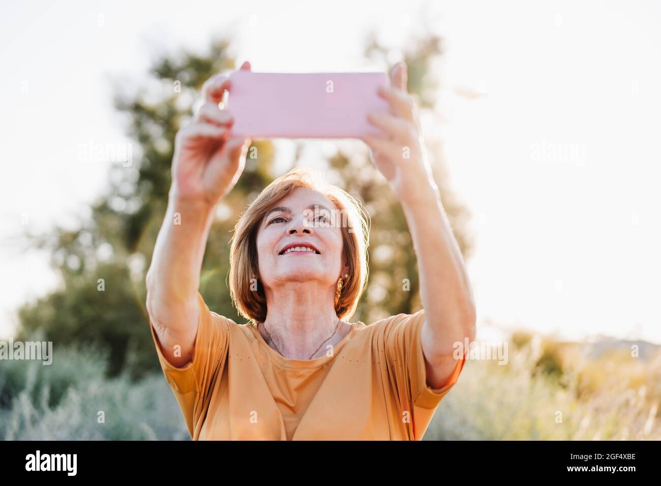 Senior woman photographing through through smart phone Stock Photo - Alamy