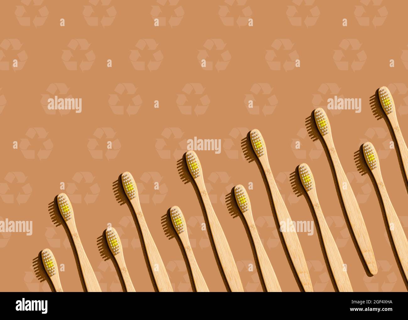 Pattern of wooden toothbrushes flat laid against brown background with ...