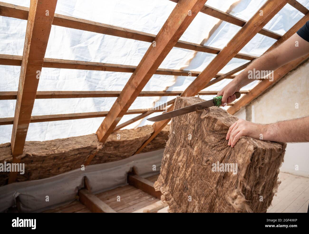 Craftsman cutting insulation material to insulate the attic Stock Photo ...