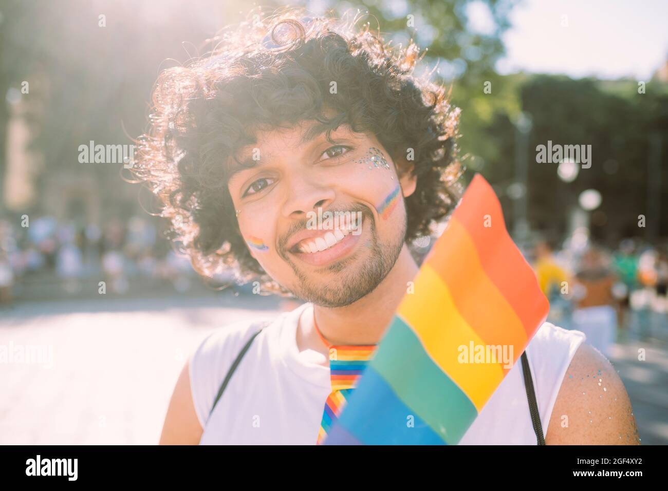 Male activist with rainbow flag in pride event on sunny day Stock Photo ...