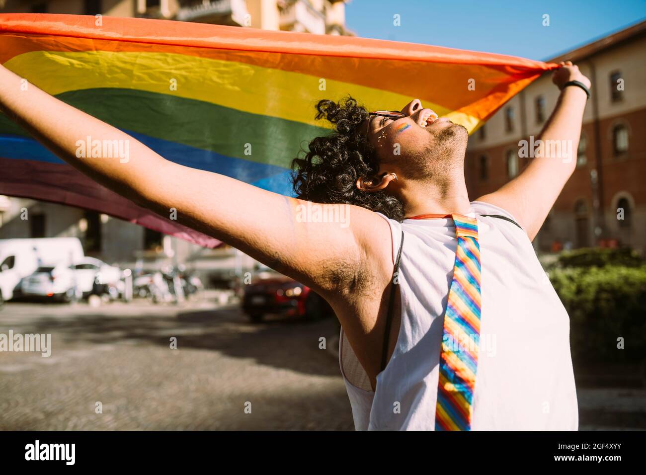 Young man holding rainbow flag hi-res stock photography and images - Alamy