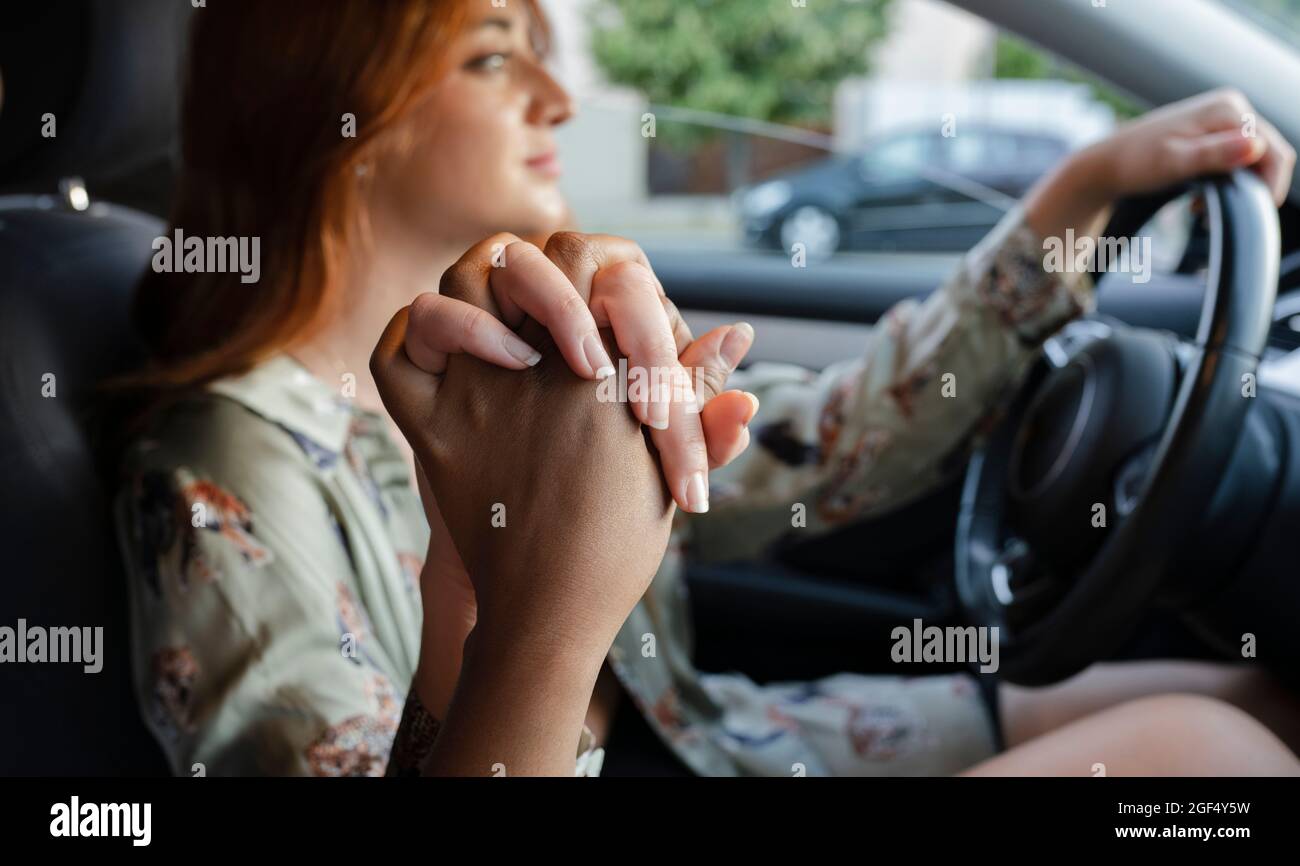 Woman holding hand of female friend while driving car Stock Photo - Alamy