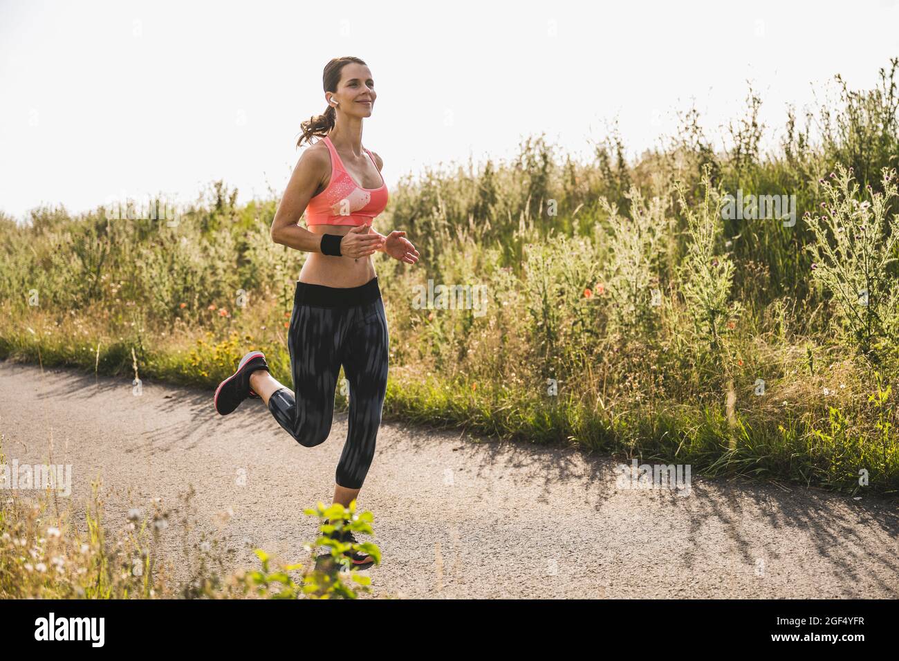 Female athlete running on road hi-res stock photography and images - Alamy
