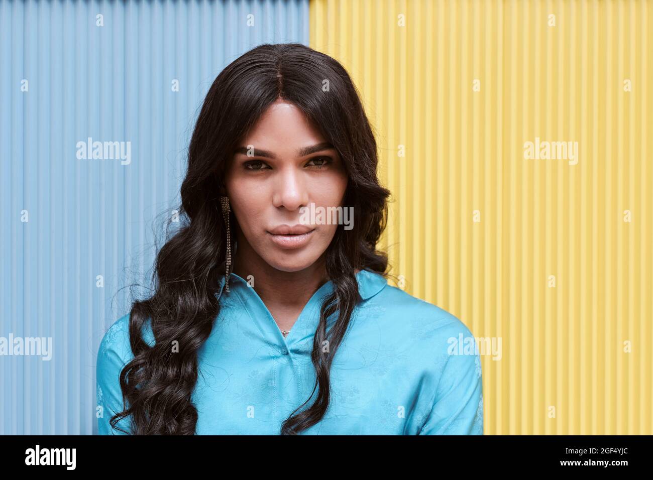 Non-binary woman staring in front of two tone wall Stock Photo - Alamy