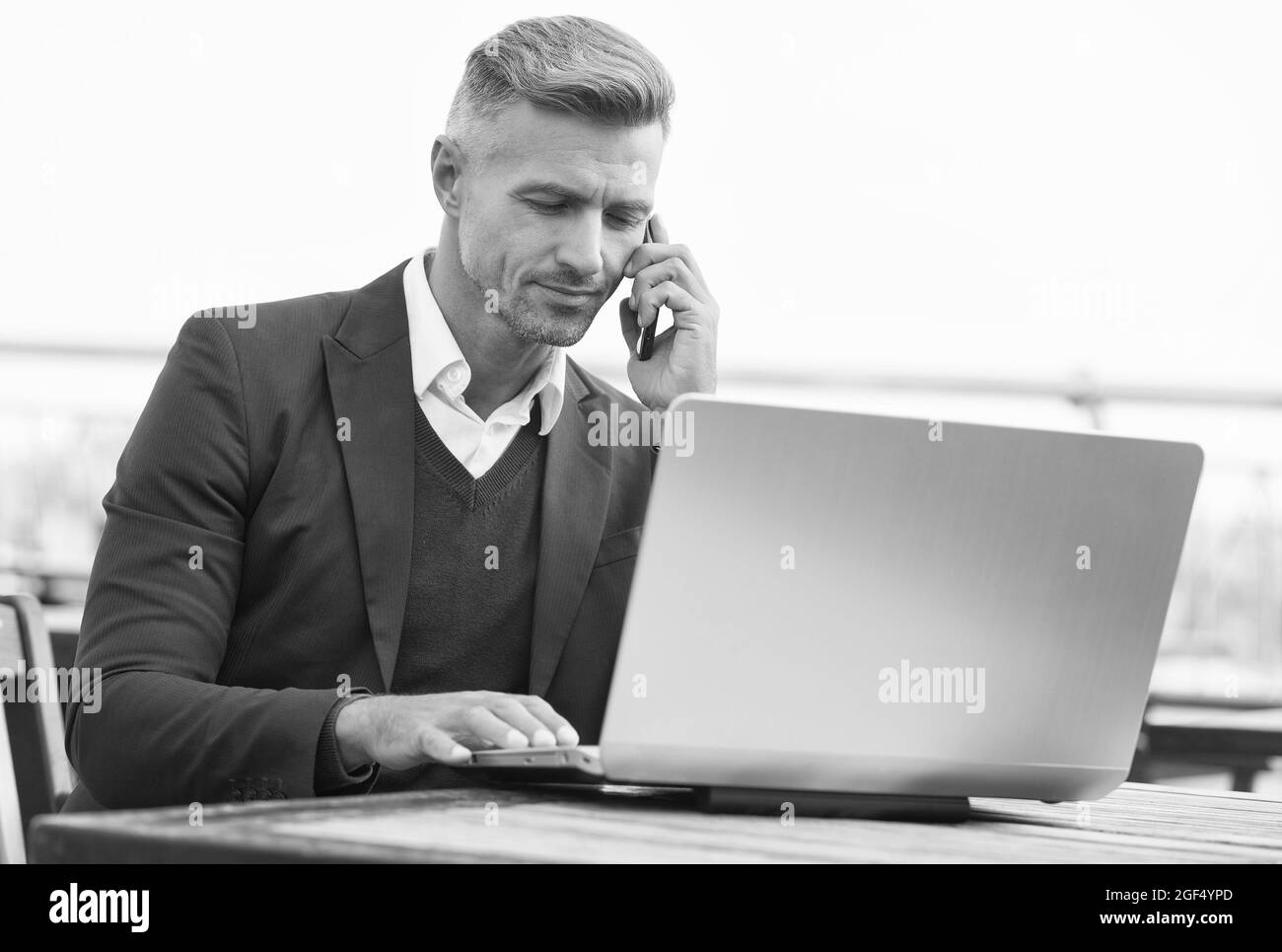 Communicating to world. Employee talk on phone working on laptop ...