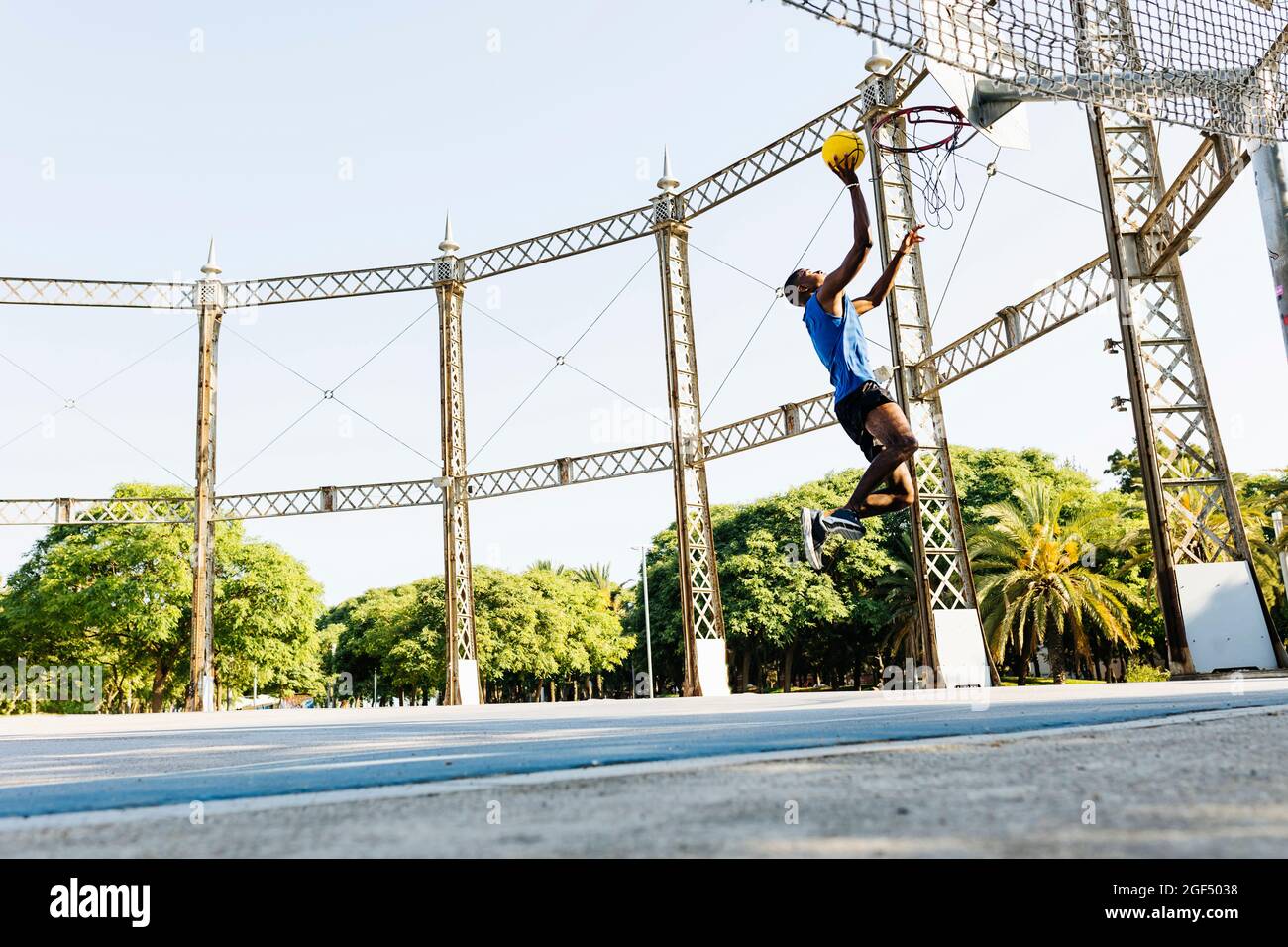 Male basketball player scoring basket at sports court Stock Photo - Alamy