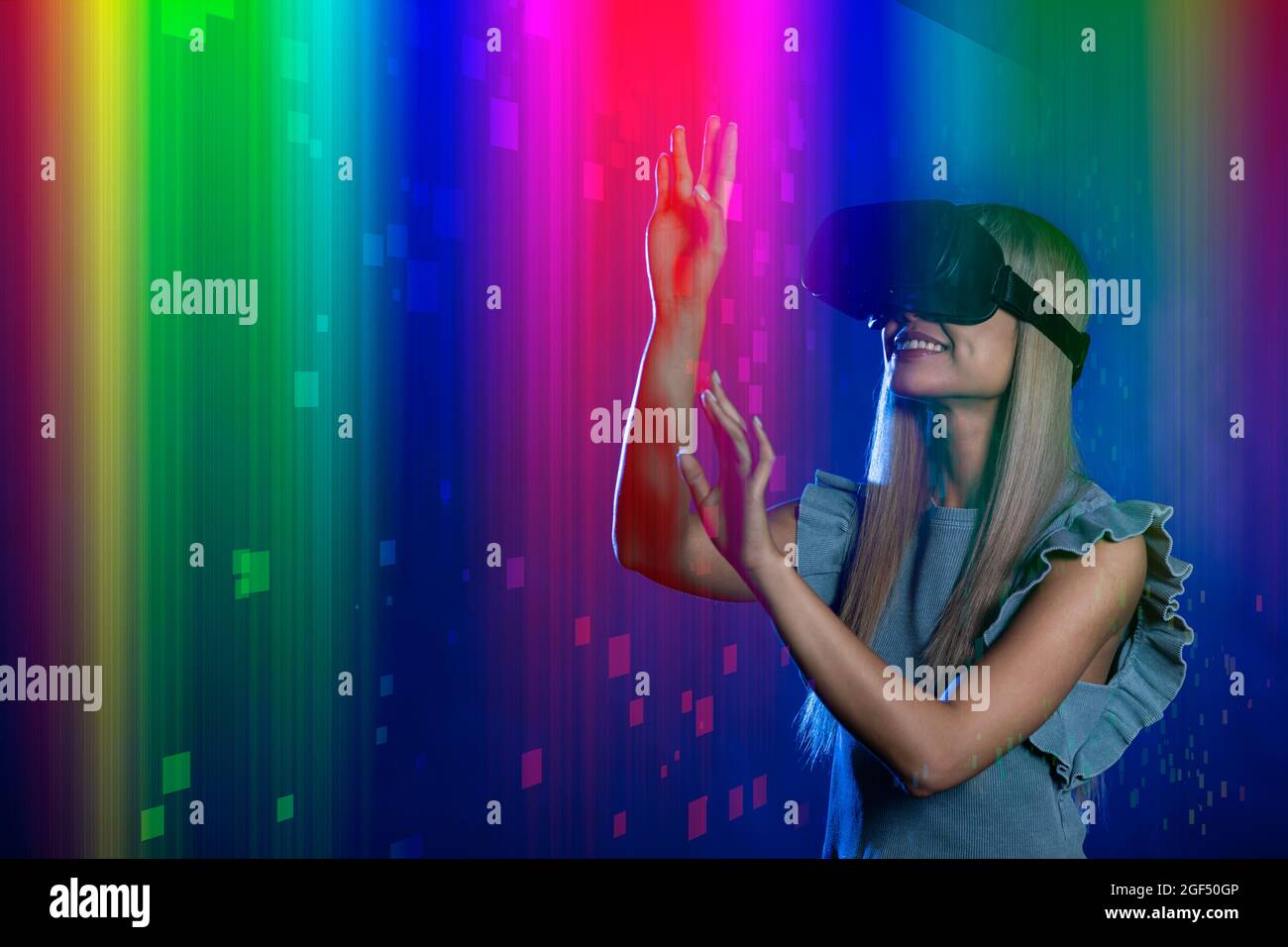 Happy woman with virtual reality simulator gesturing over multi-colored ...
