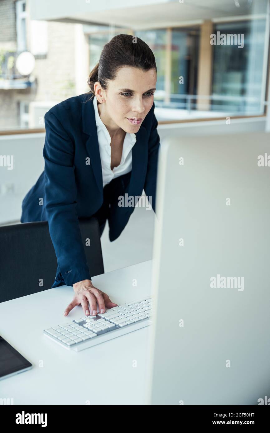 Female professional using computer at desk in office Stock Photo - Alamy