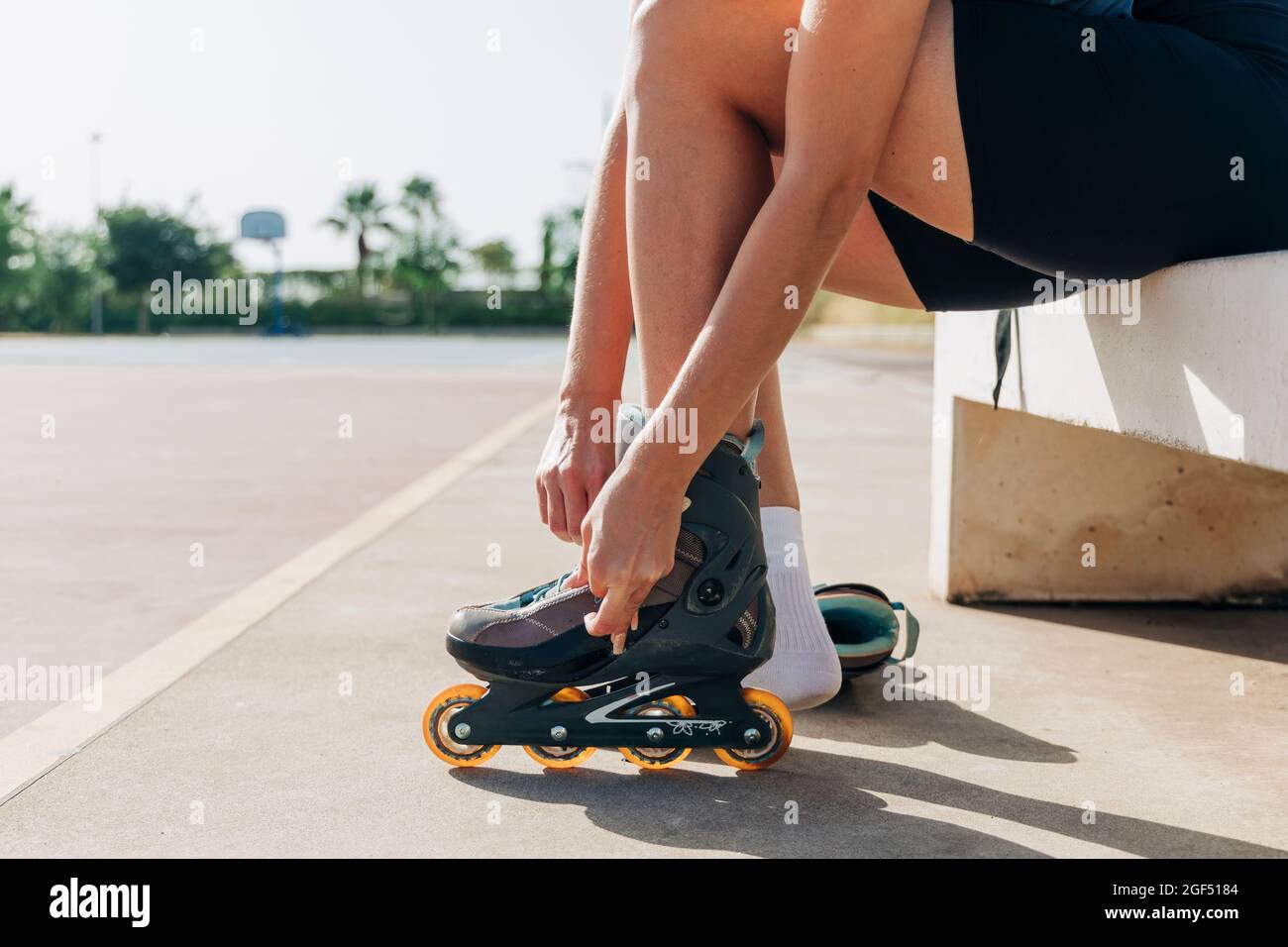 Woman wearing inline skate at basketball court during sunny day Stock ...