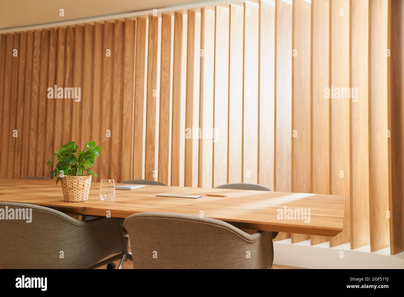 Conference table in front of wooden blinds at office Stock Photo - Alamy