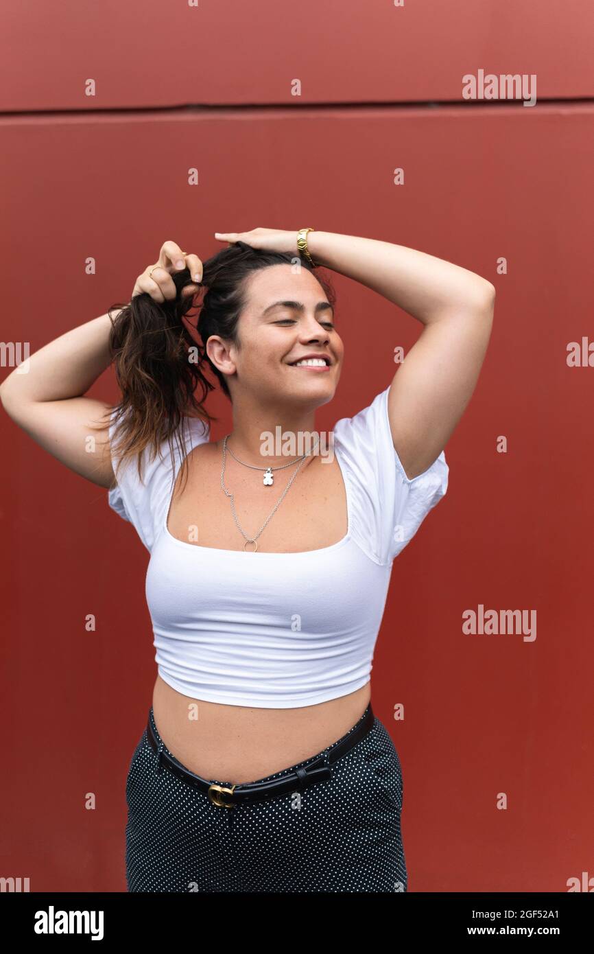 Woman tying hair standing hi-res stock photography and images - Alamy