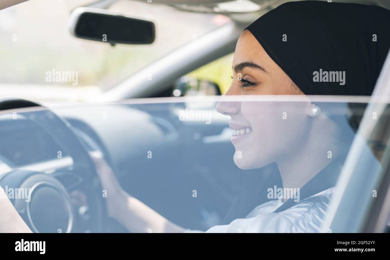 Smiling young woman driving car Stock Photo - Alamy