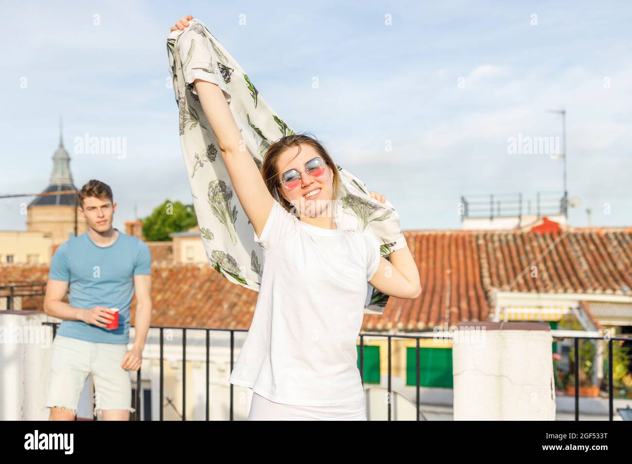 Young woman dancing with scarf on rooftop Stock Photo - Alamy