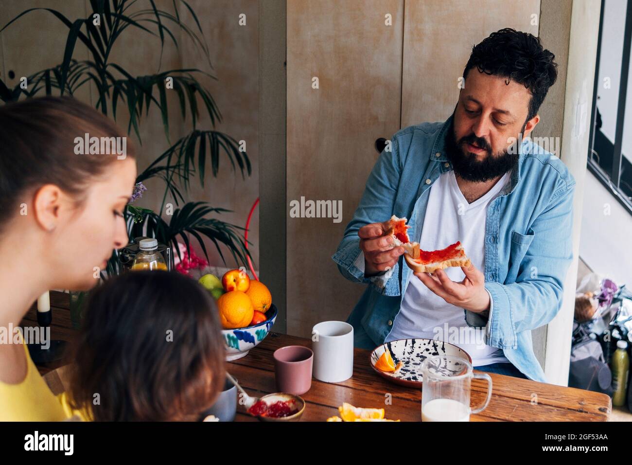 Man eating food while sitting with family at table Stock Photo - Alamy
