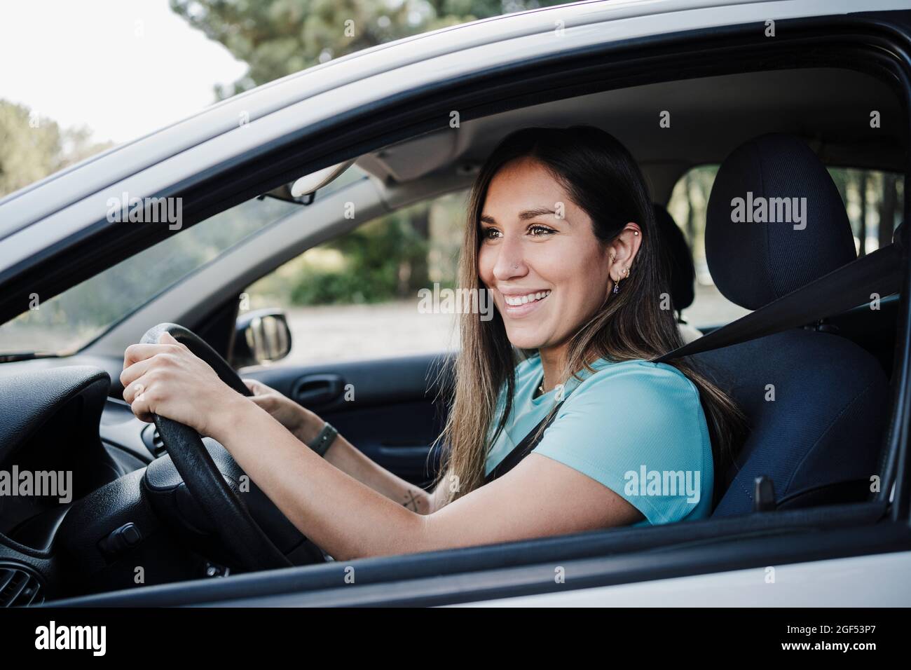Smiling beautiful woman driving car Stock Photo - Alamy