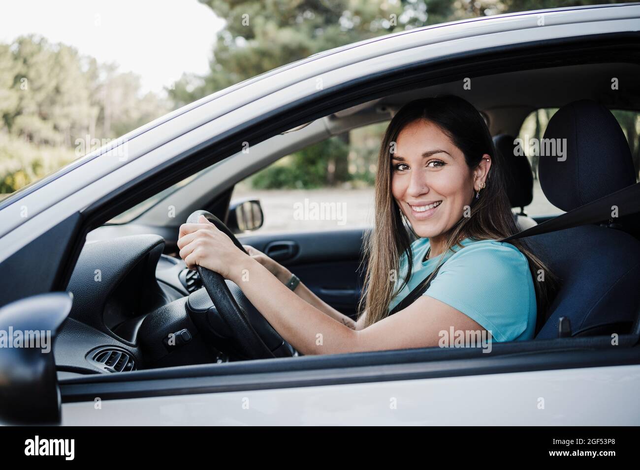 Smiling young woman driving car Stock Photo - Alamy