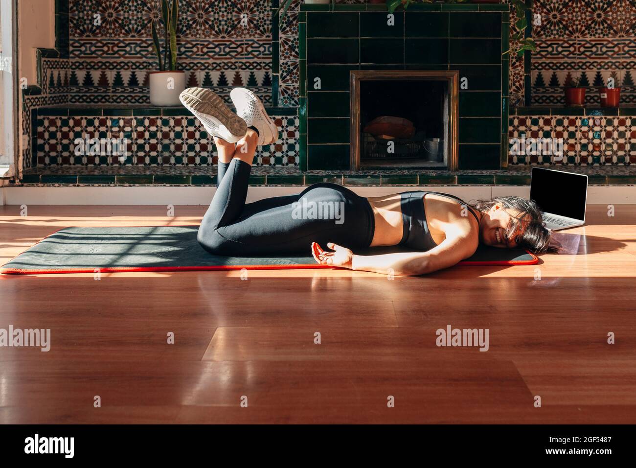 Tired young woman lying on exercise mat during home workout Stock Photo ...