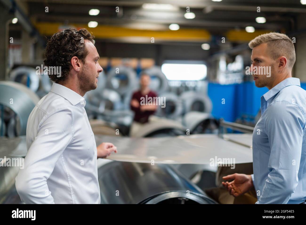 Businessman discussing with colleague while working at industry Stock ...