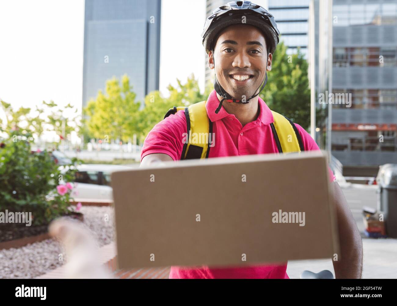 Happy male delivery person giving package to customer Stock Photo - Alamy