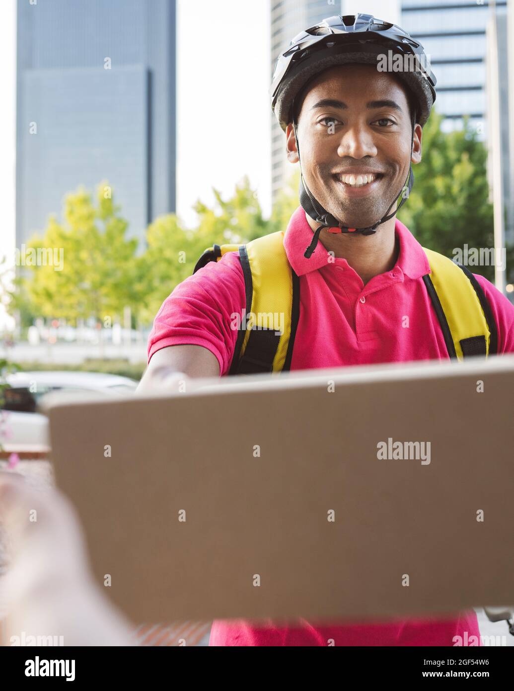 Happy delivery man giving package to customer Stock Photo - Alamy
