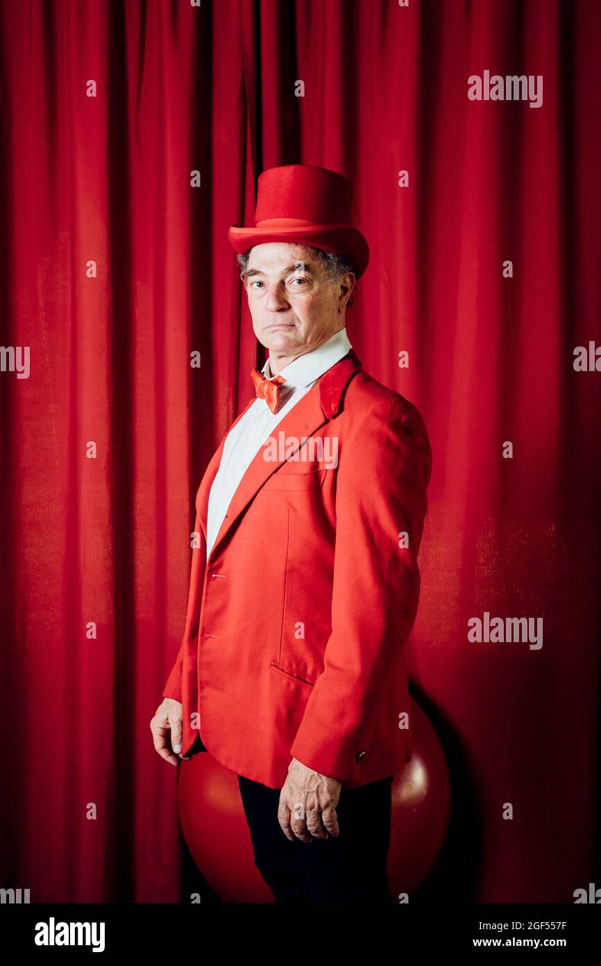 Male artist wearing hat standing by stage curtain Stock Photo - Alamy