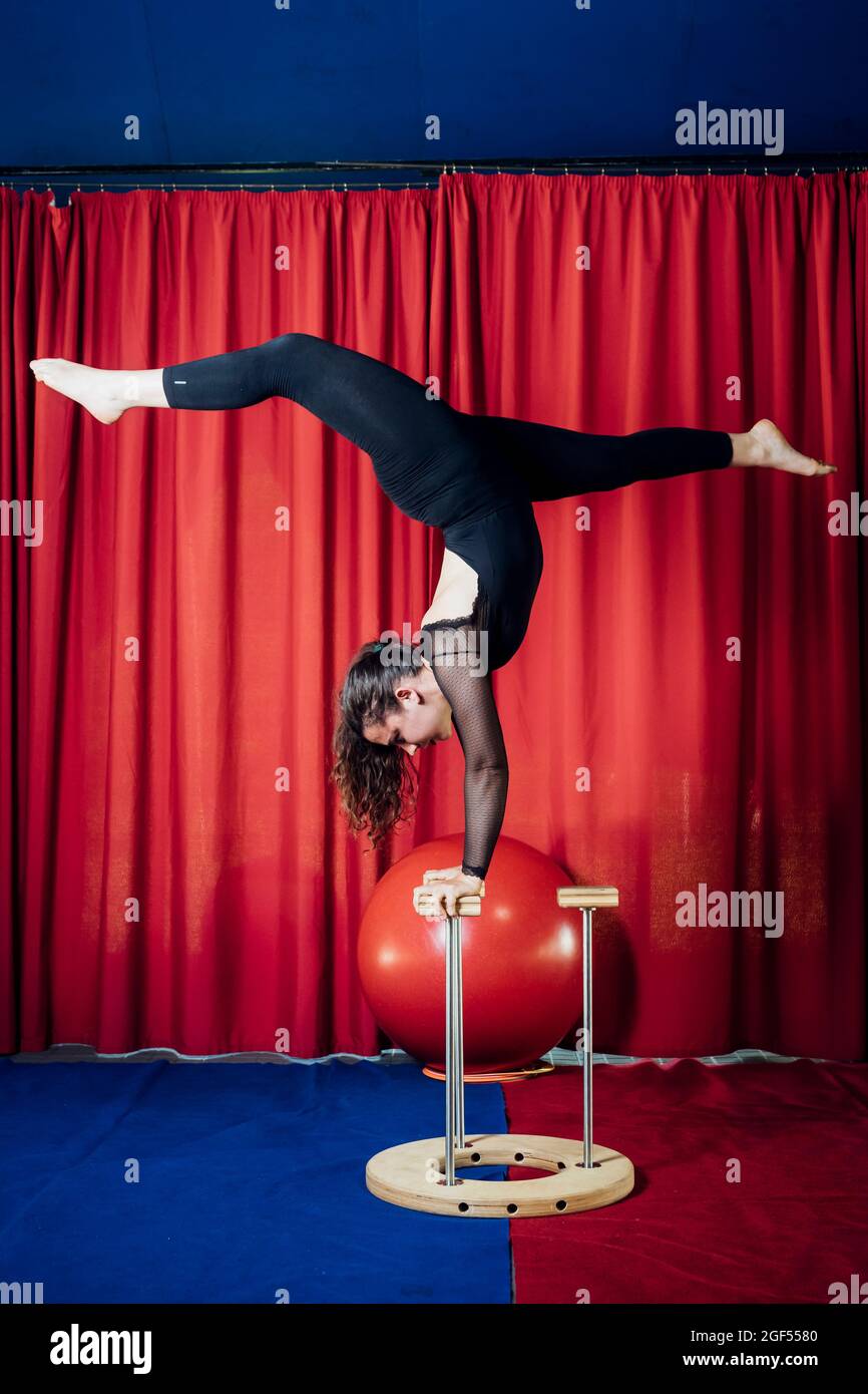Female artist performing on handstand cane in circus Stock Photo - Alamy