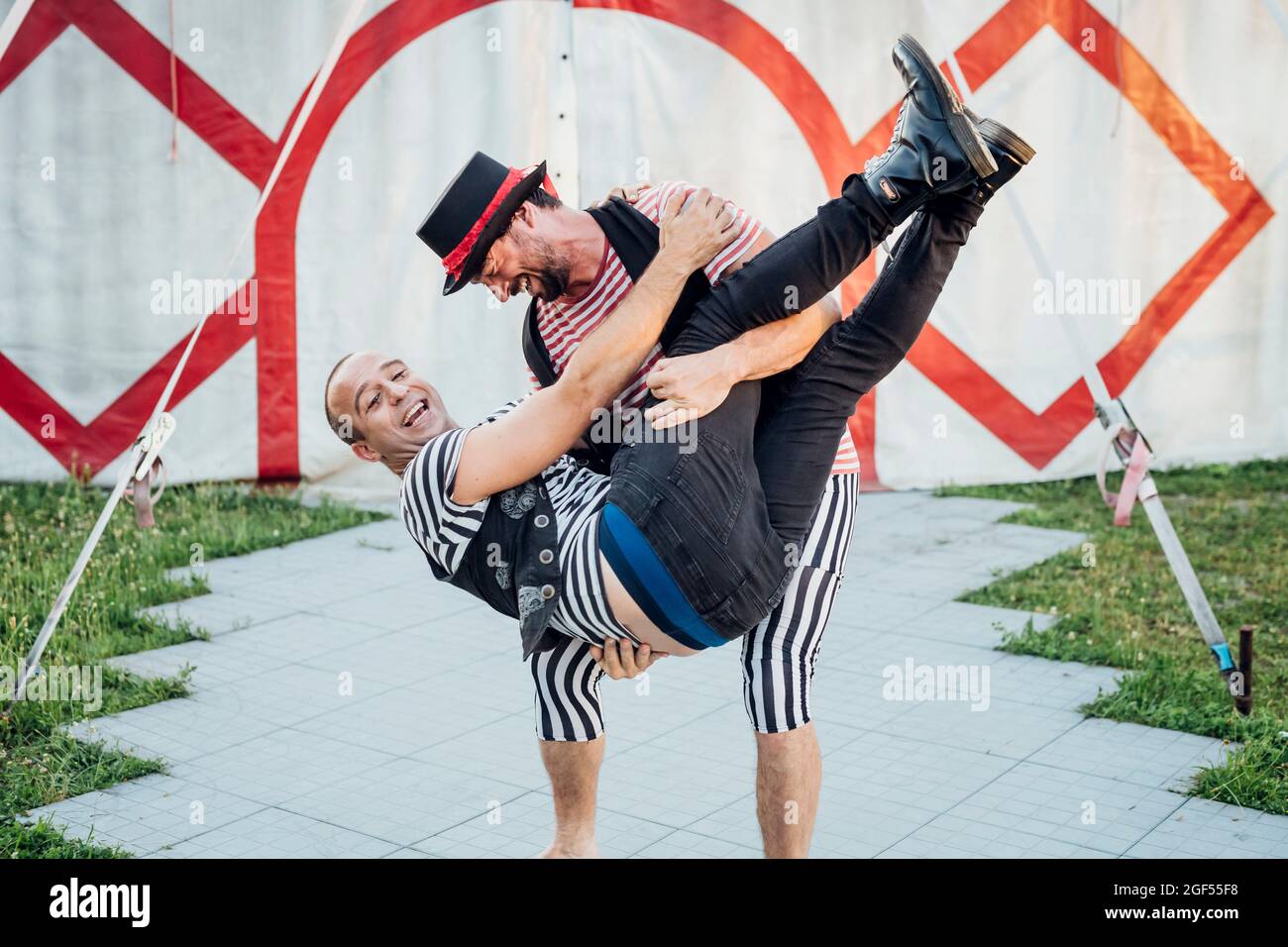 Male acrobats dancing in front of circus tent Stock Photo - Alamy