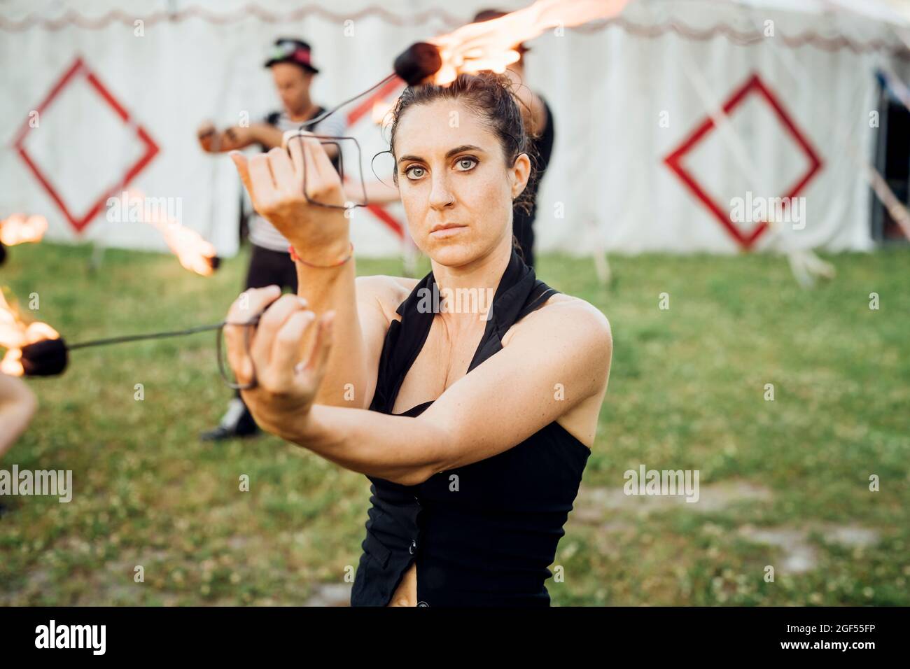 Female artist holding fire equipment while practicing at circus Stock ...
