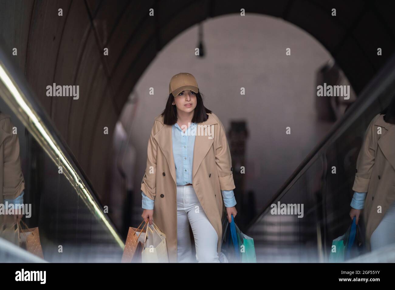 Woman moving up an escalator hi-res stock photography and images - Alamy