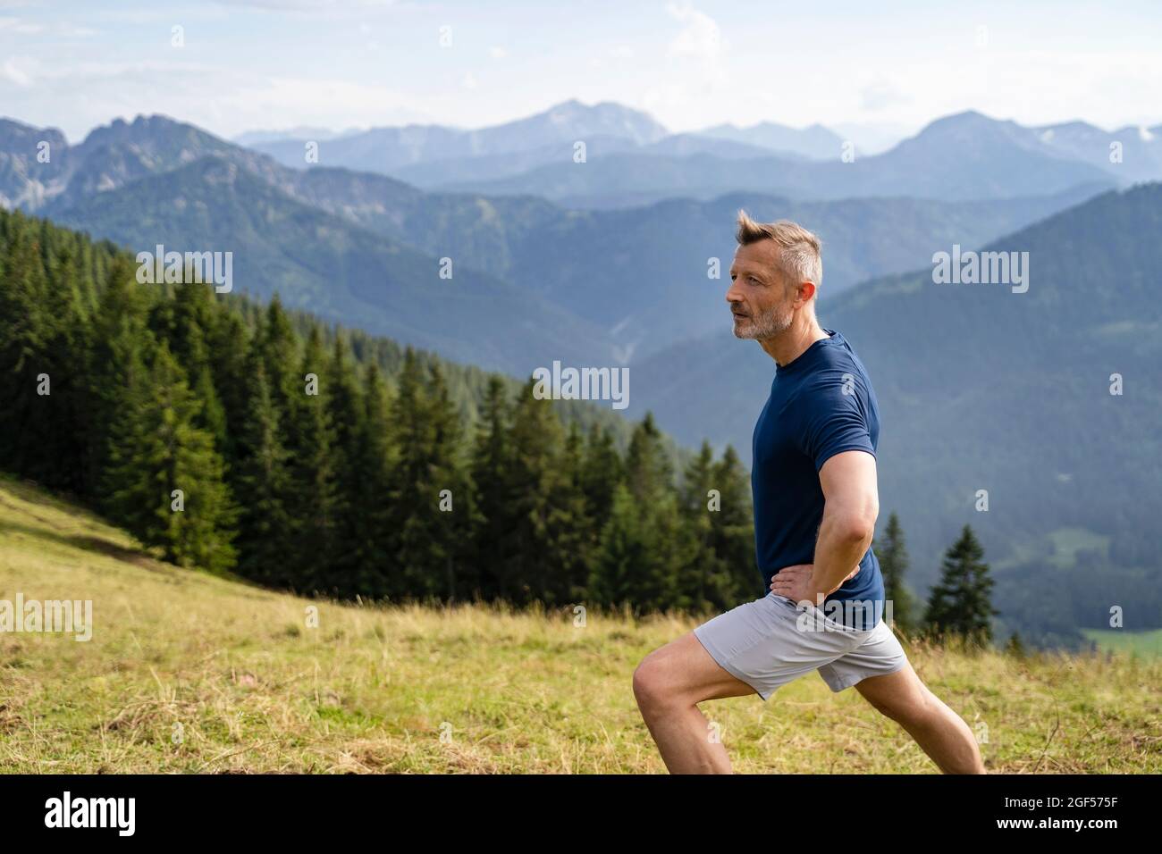 Man with hand on hip stretching while exercising Stock Photo - Alamy