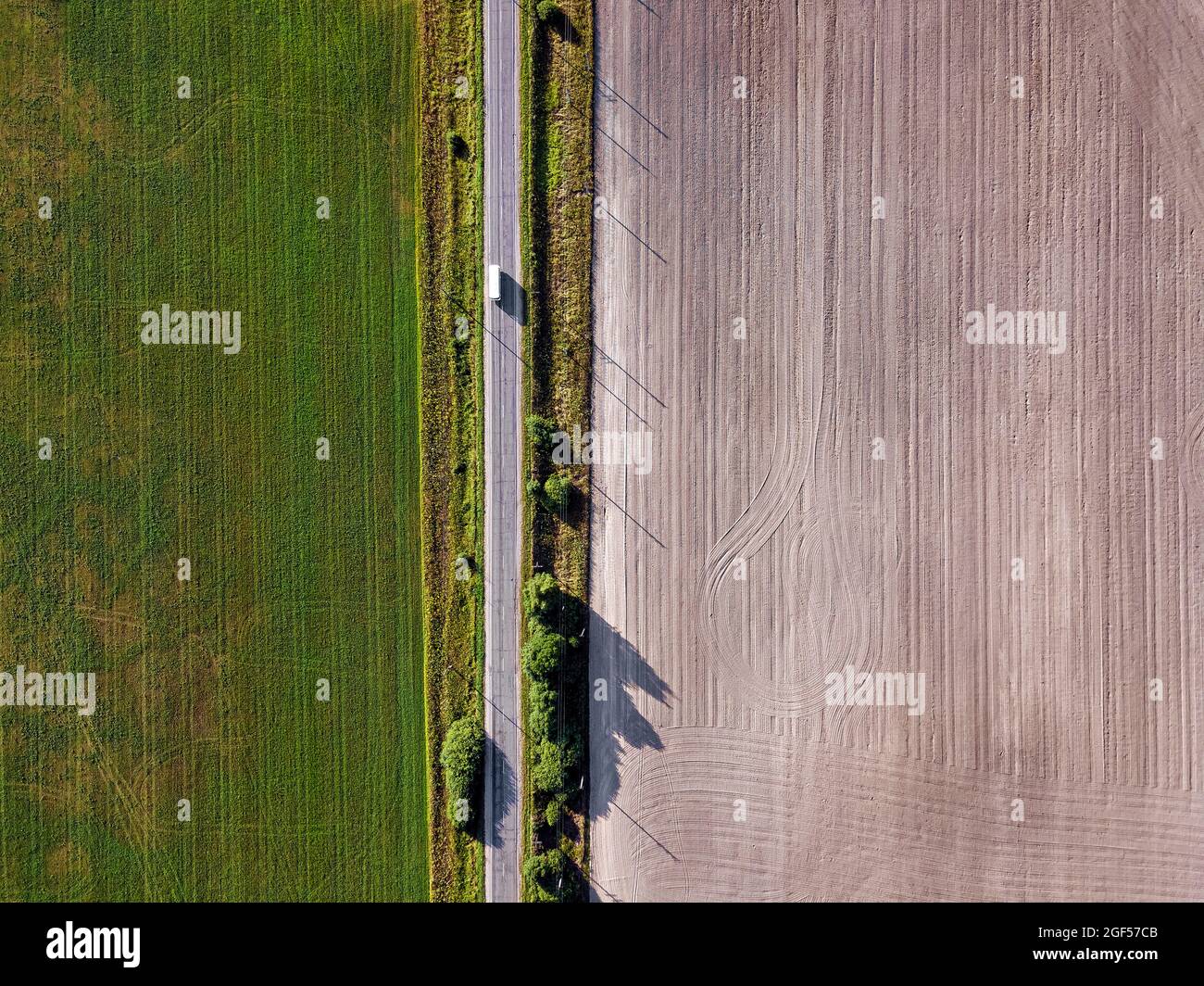 Aerial view of bus driving along country road separating two ...