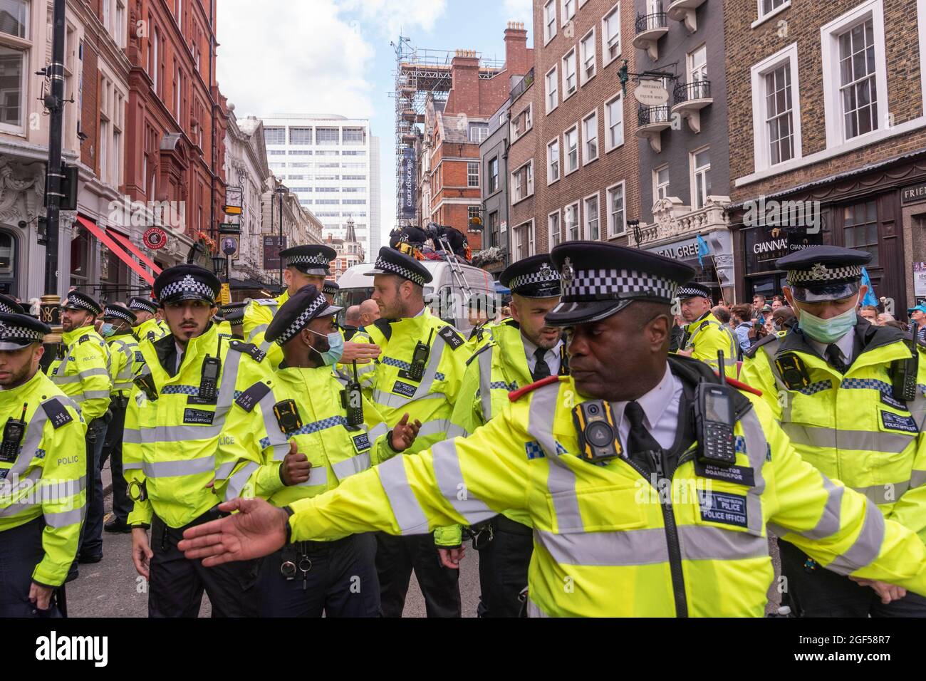 London, UK. 23rd Aug, 2021. Police officers keep protesters back while ...
