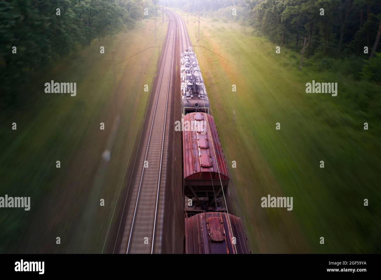A freight train loaded with resources delivers cargo through the forest ...