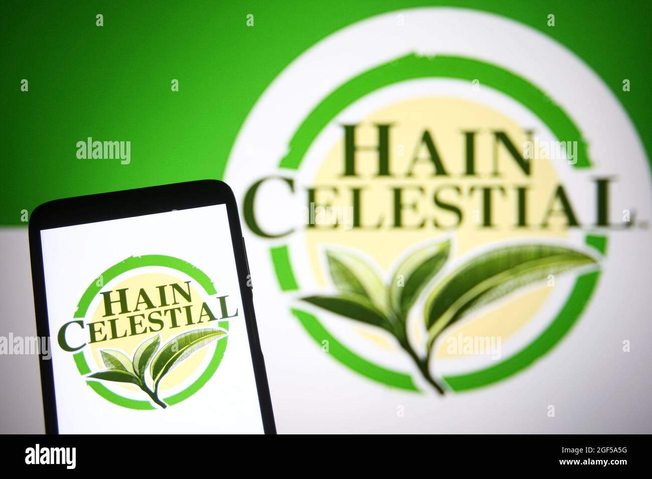In this photo illustration, Hain Celestial Group logo is seen displayed on a smartphone and a pc ...